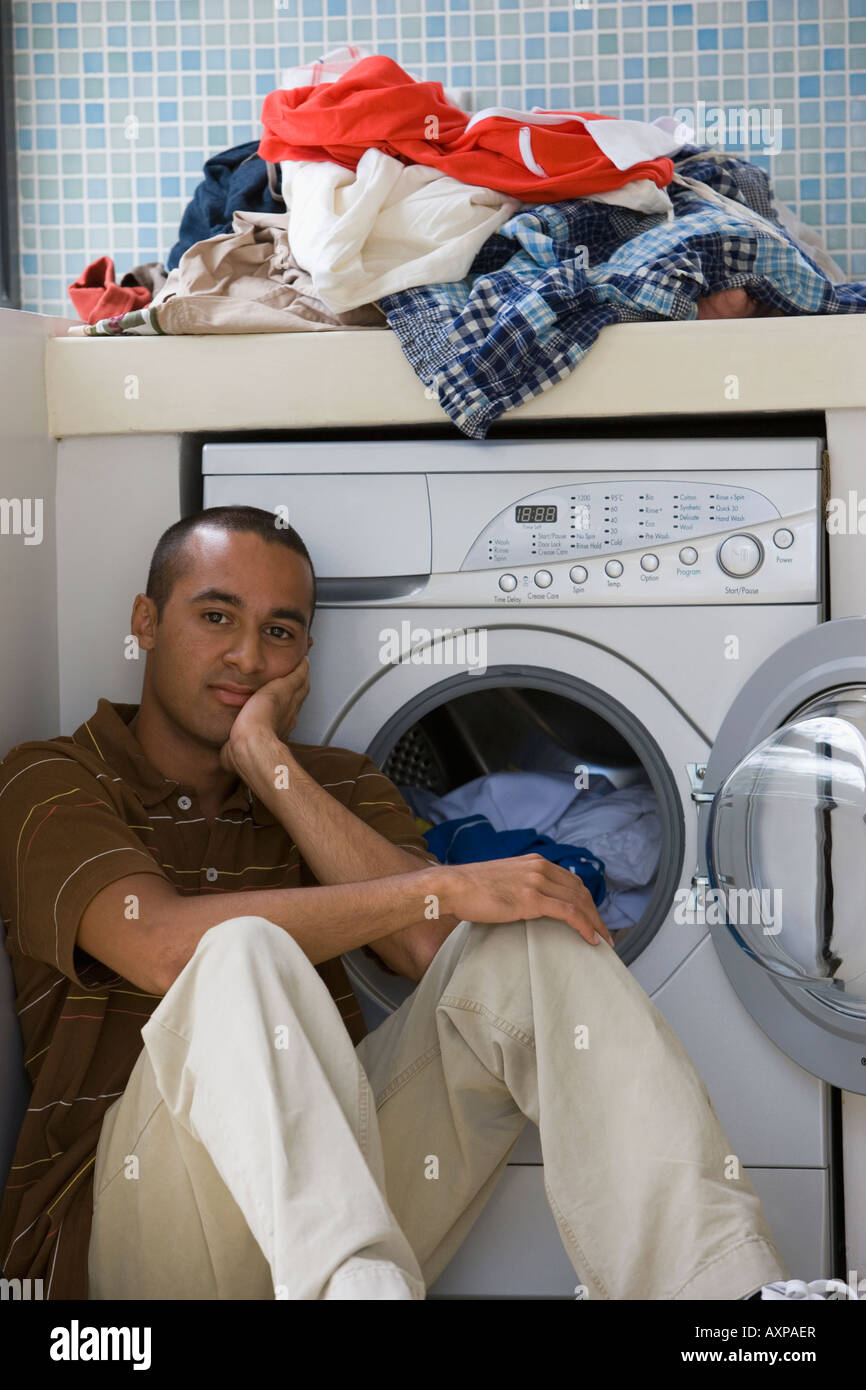 Young man doing laundry Stock Photo - Alamy