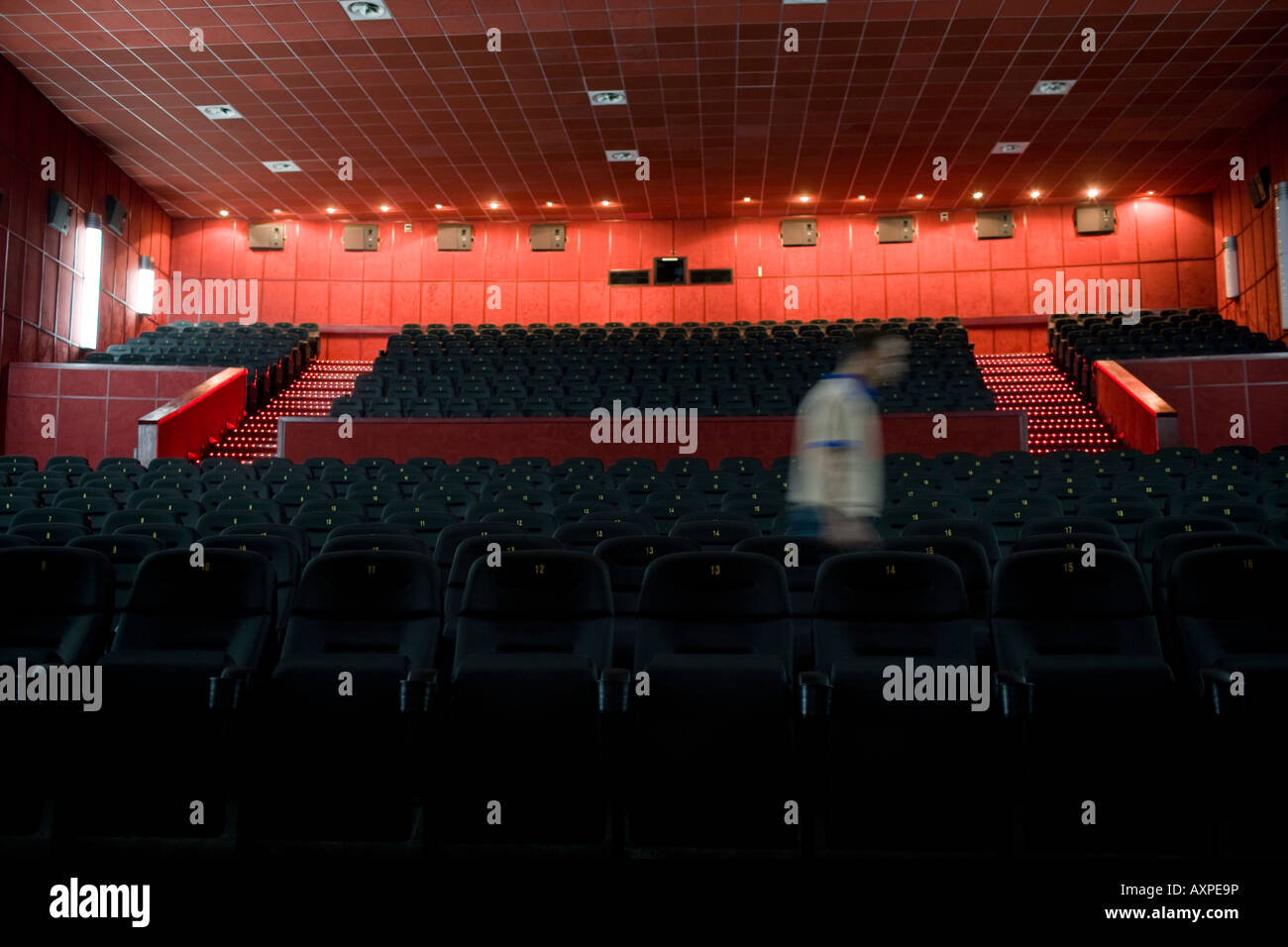 public hall with a single person walking among seats Stock Photo - Alamy