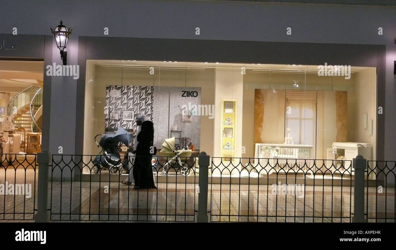 A local couple walk past a shop at Villaggio Mall, Doha, Qatar Stock ...
