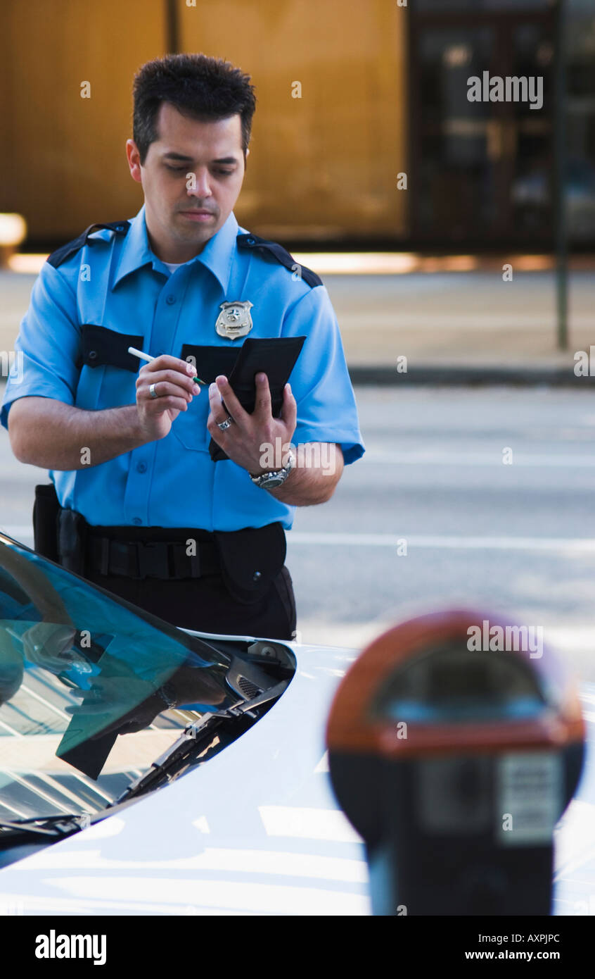 Policeman writing parking ticket Stock Photo - Alamy