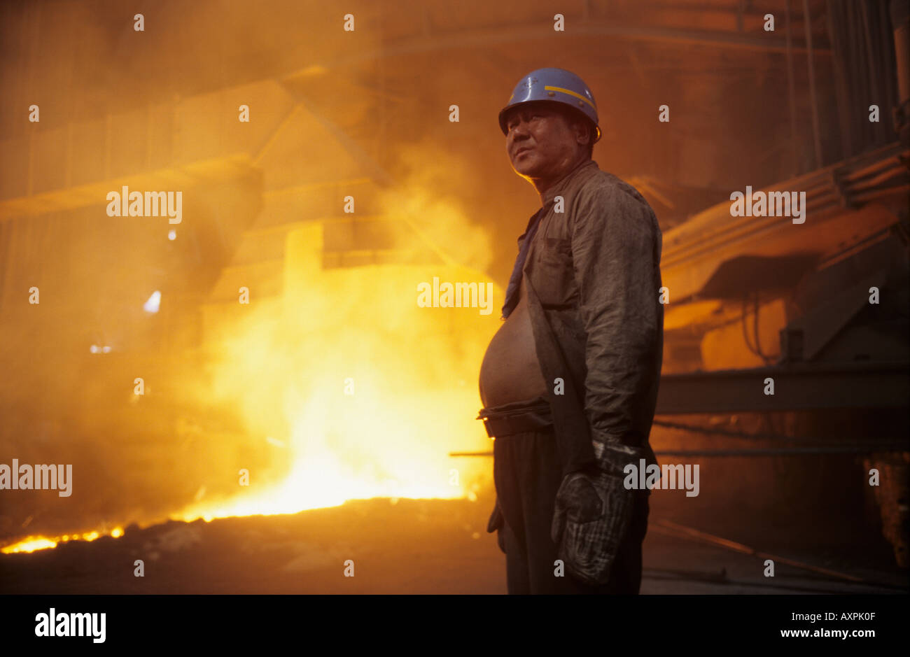 A steel worker in front of a blast furnace in Benxi Iron and Steel ...