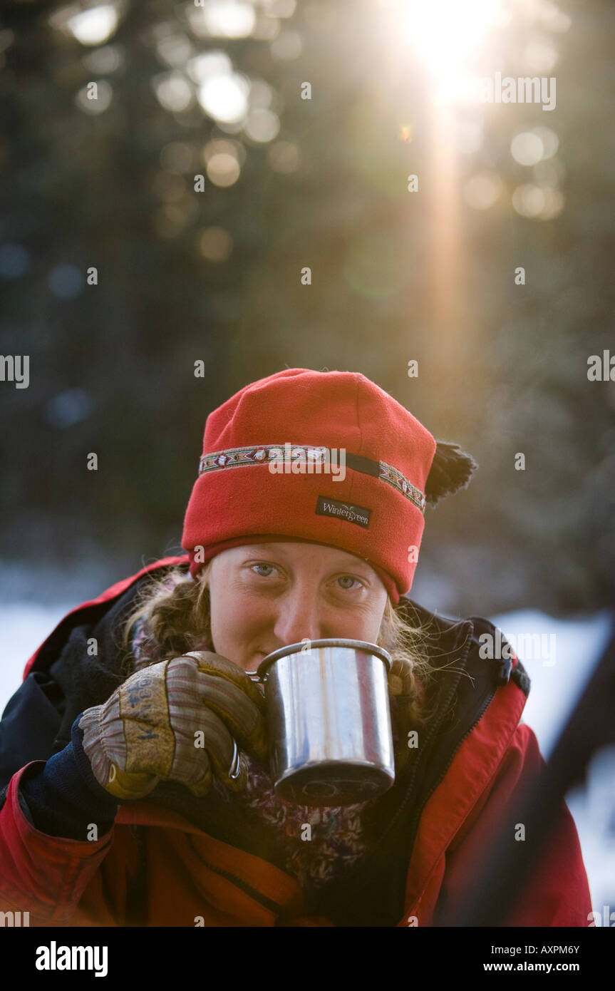 A WINTER CAMPER TAKES A DRINK OF MORNING COFFEE FROM TIN CUP BOUNDARY ...