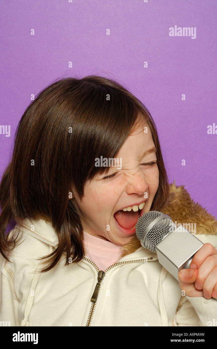 Young girl age 9 having fun singing into a microphone Stock Photo - Alamy