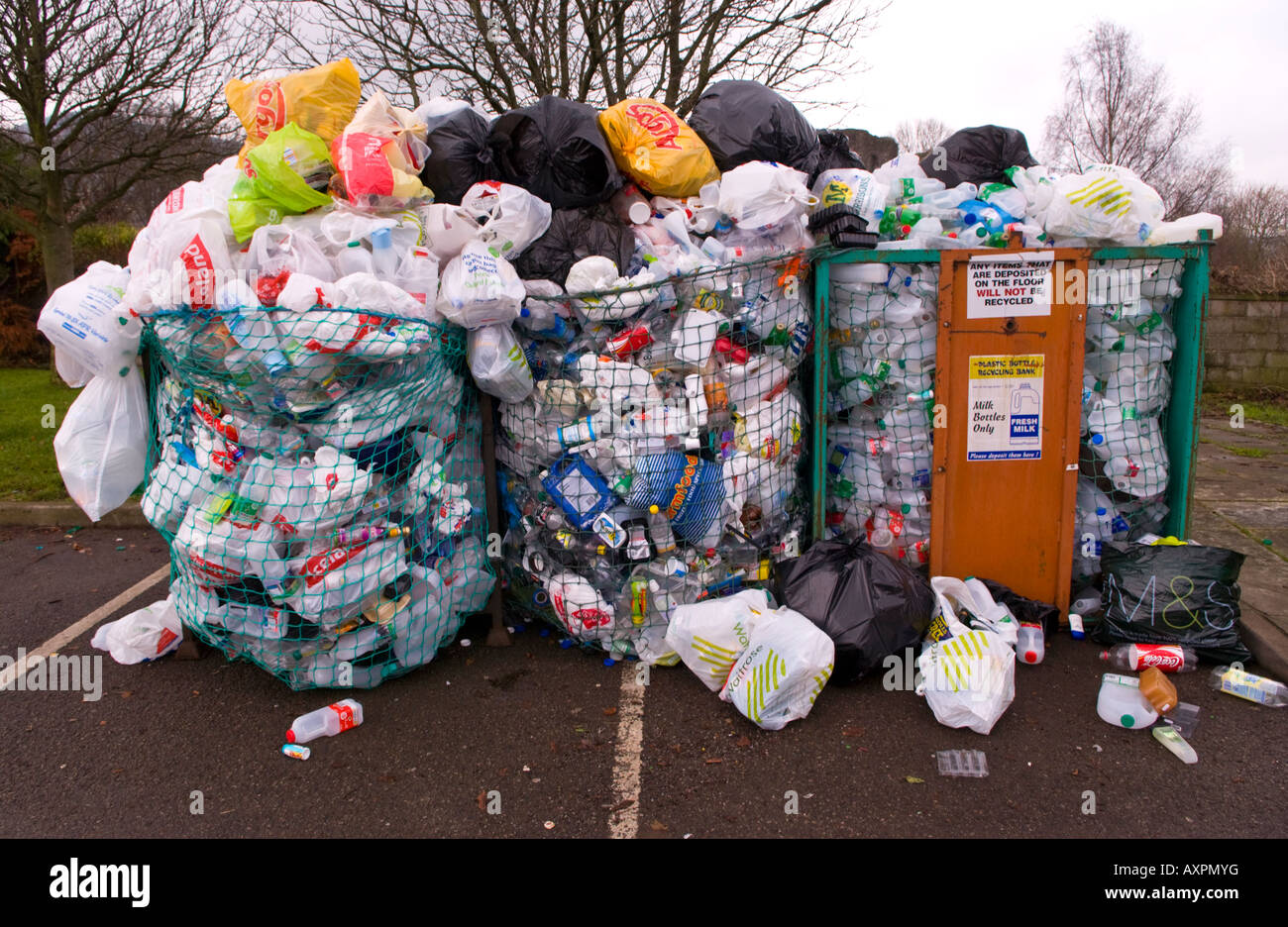 Plastic recycling bank overflowing with plastic bags at car park in ...