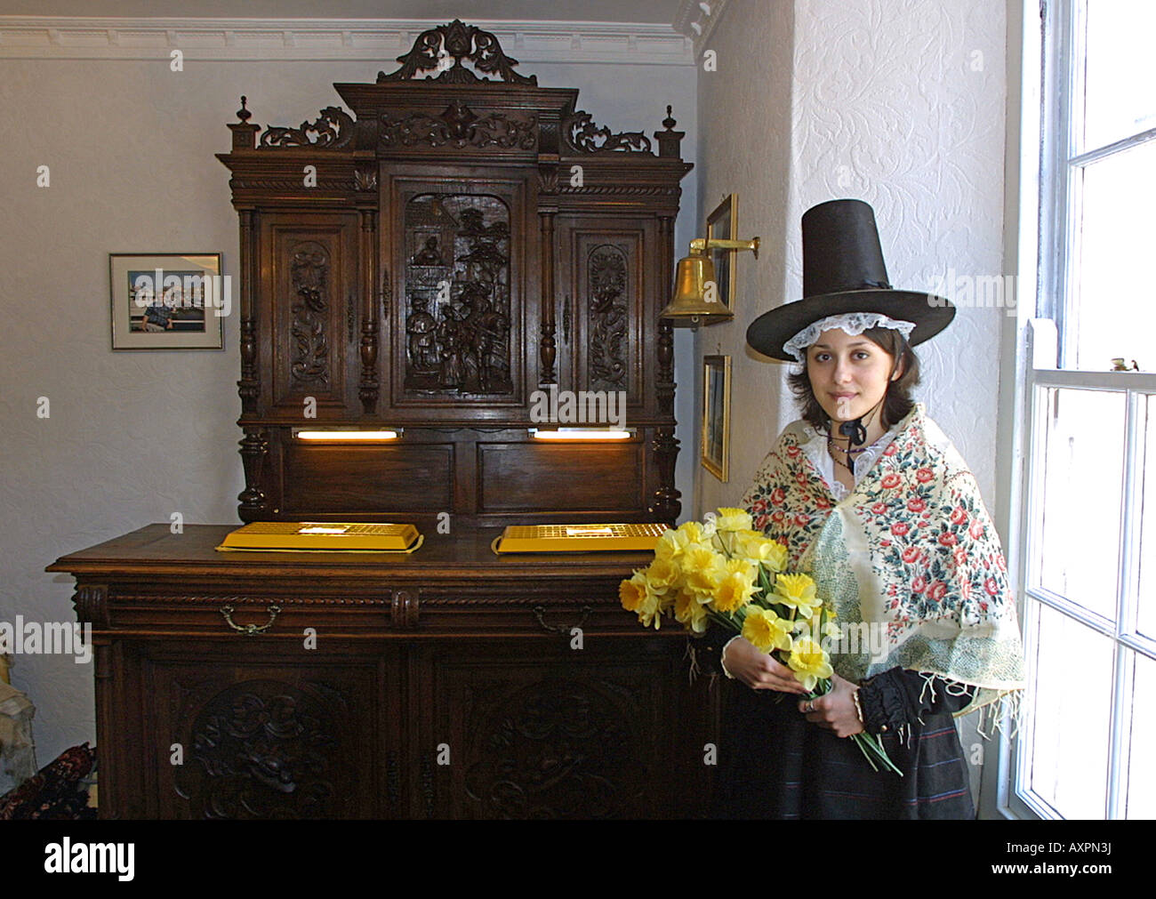 Beautiful girl in welsh costume with yellow daffodils and hat and shawl ...