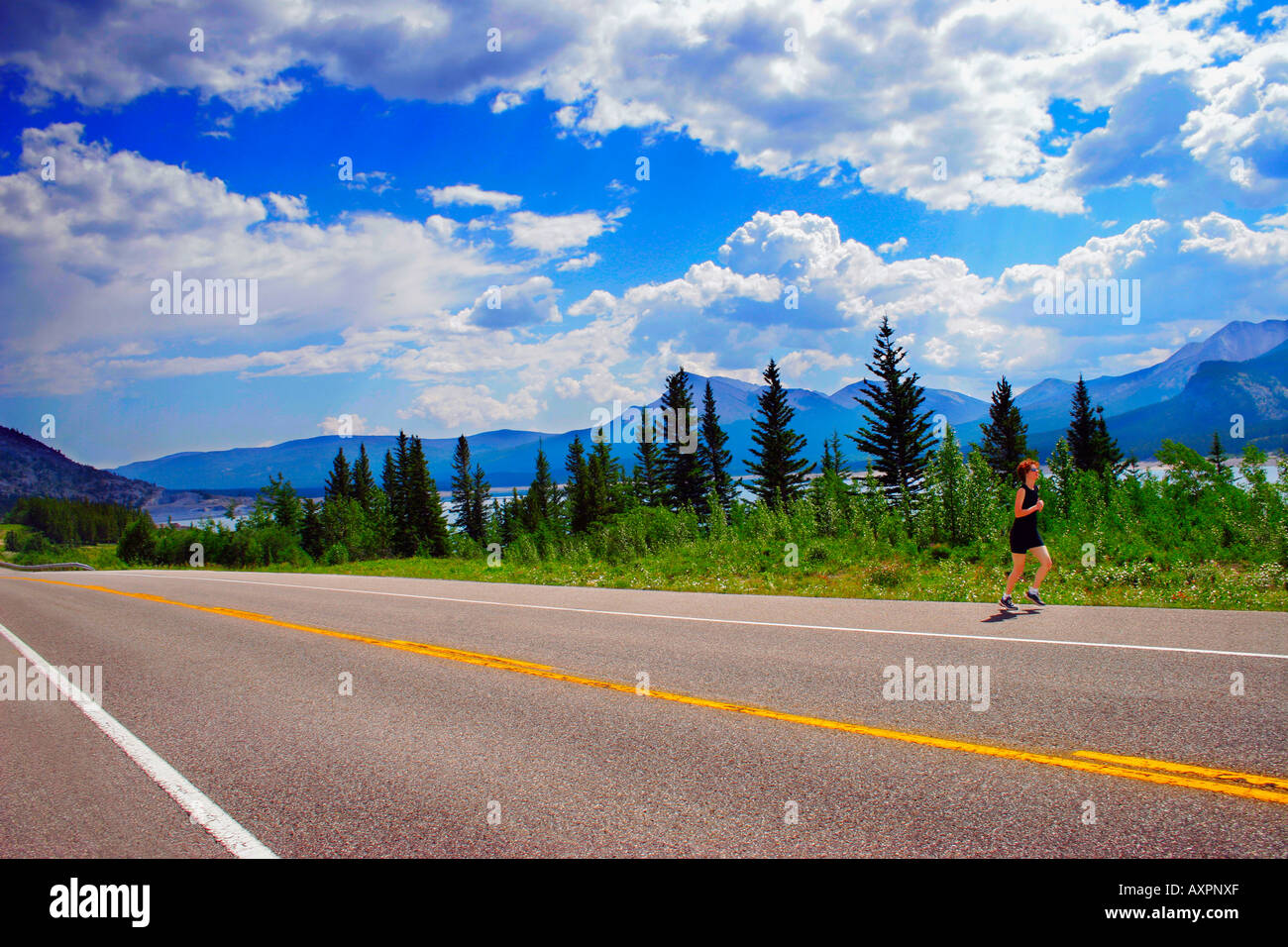 A woman runs along the roadside amidst beautiful scenery Stock Photo ...