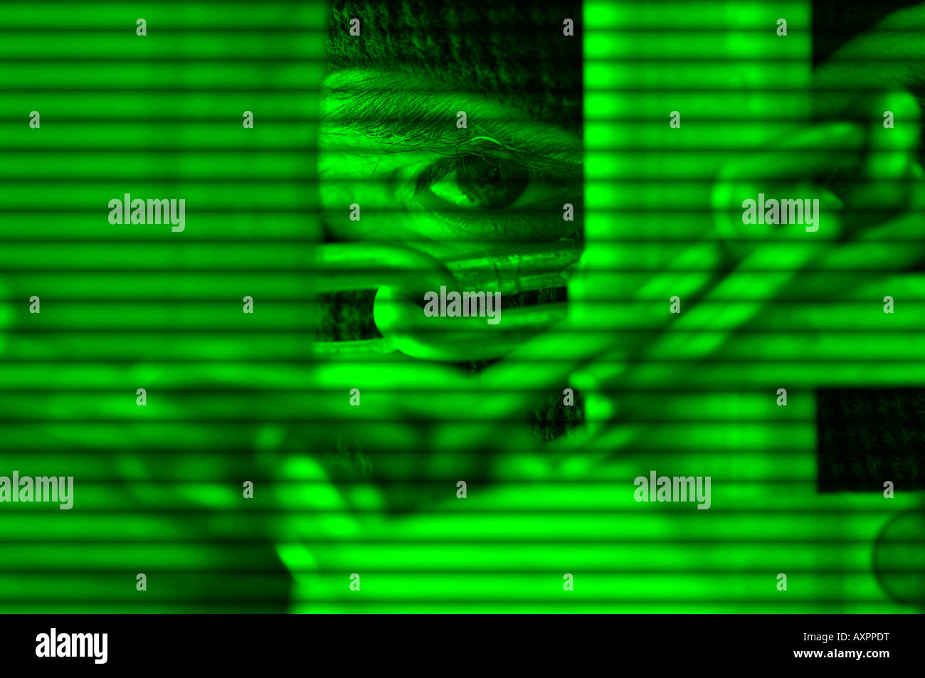 terrorist with ski mask peering through padlocked chain link fence ...