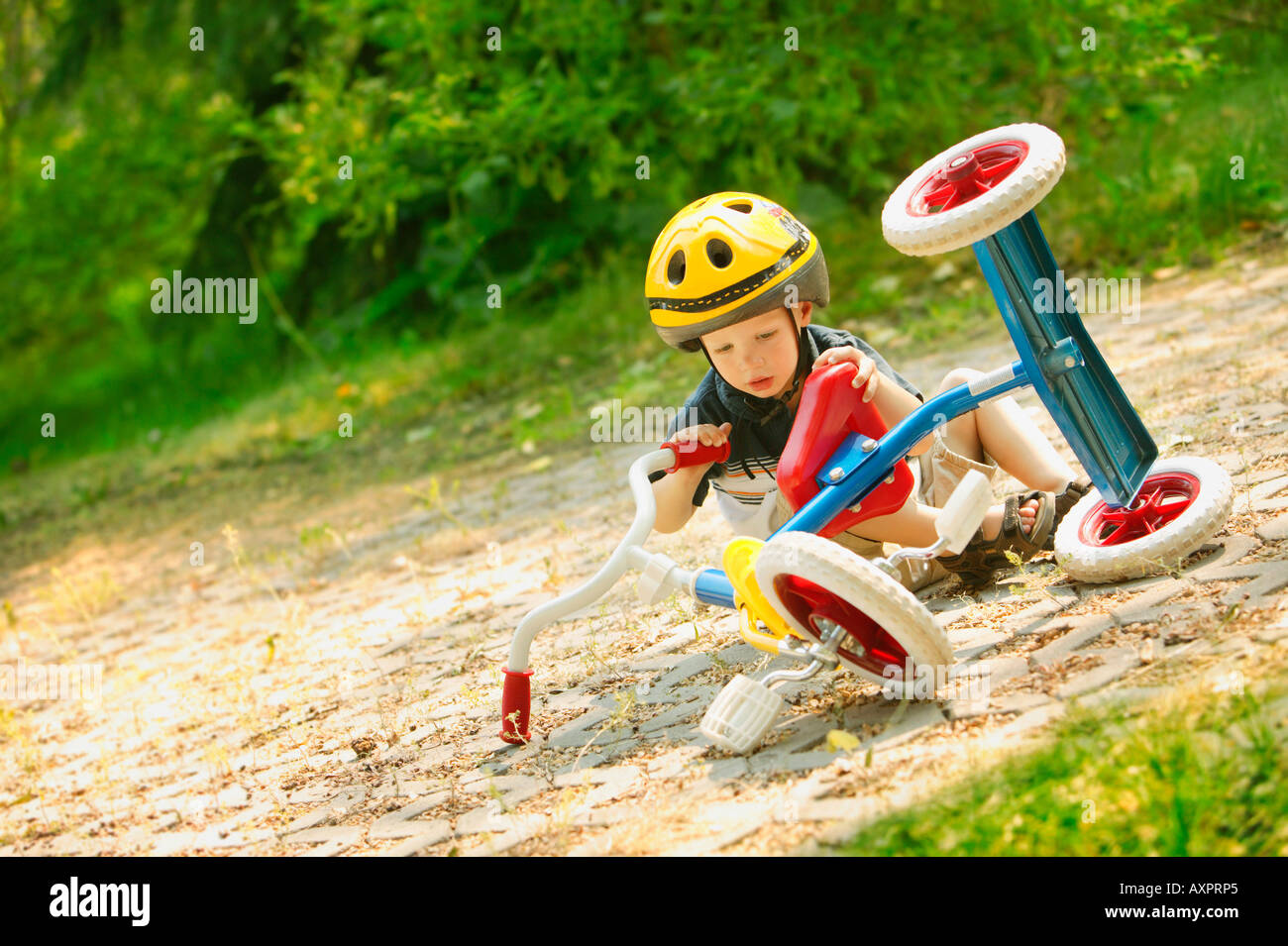 Child falling off tricycle Stock Photo - Alamy