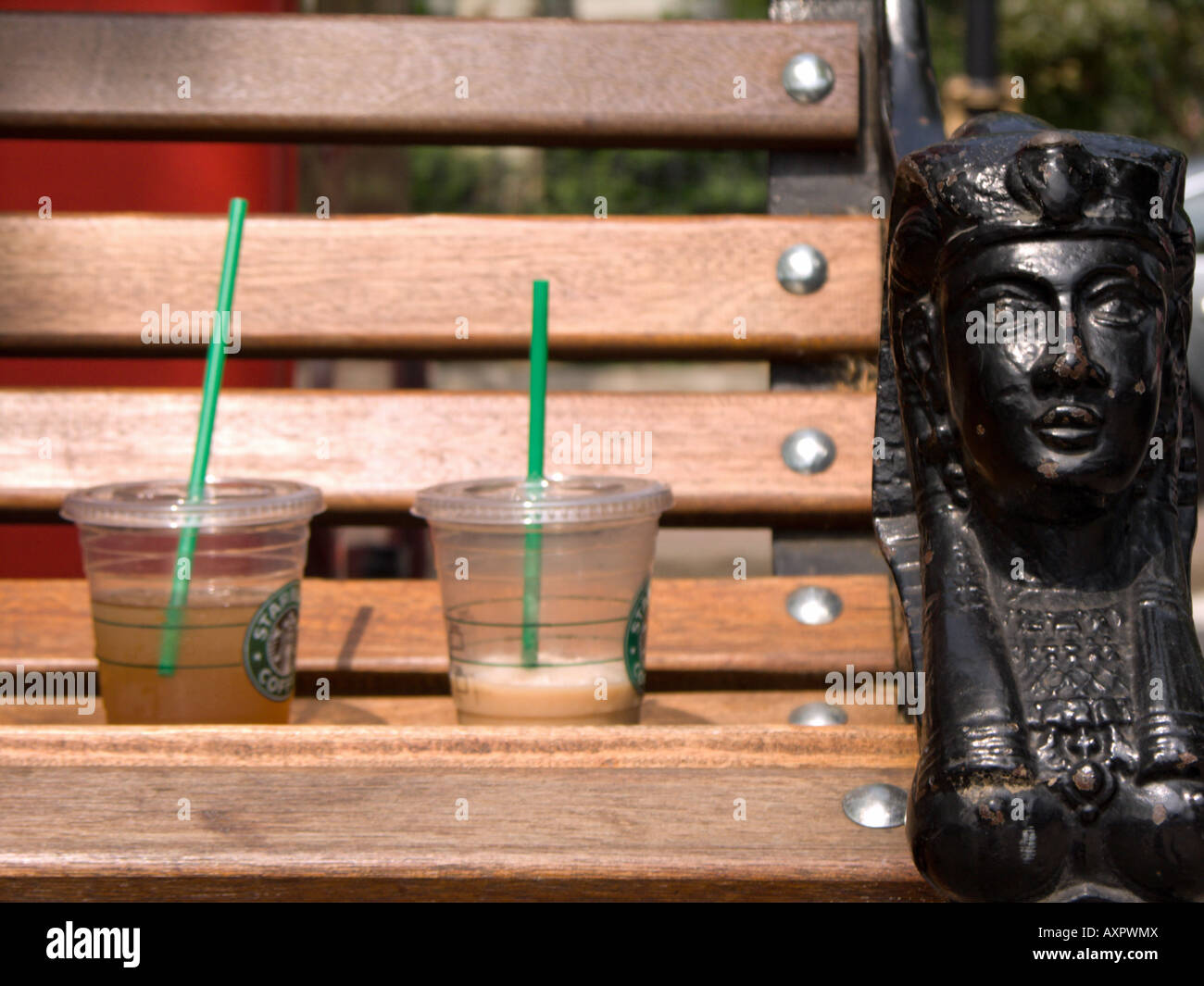 two discarded starbucks drinks containers on a wooden bench decorated ...