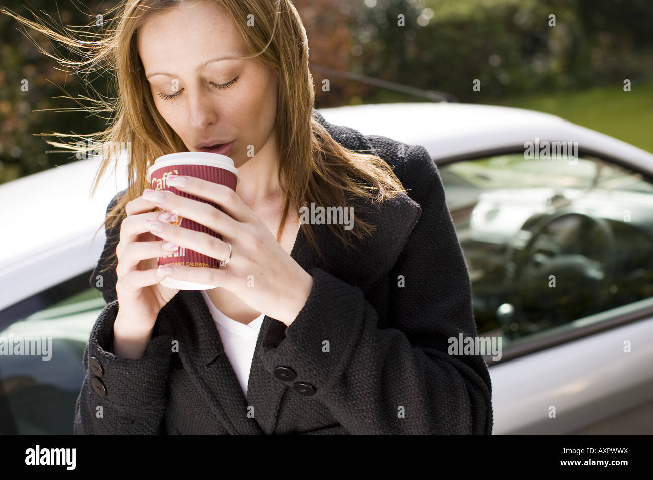 Woman taking coffee break from driving Stock Photo - Alamy