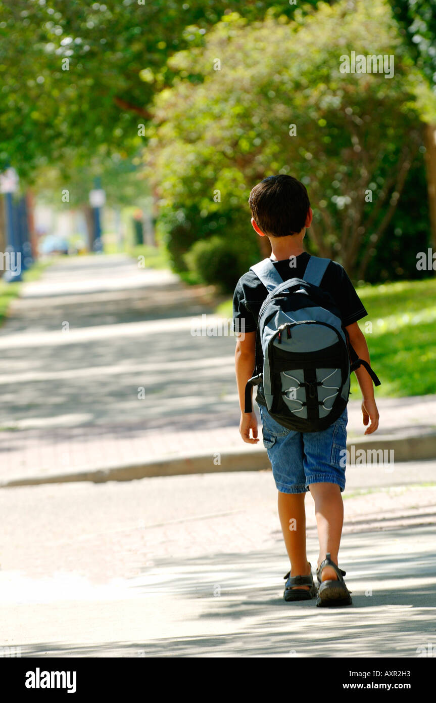 Boy taking a walk down the sidewalk Stock Photo - Alamy