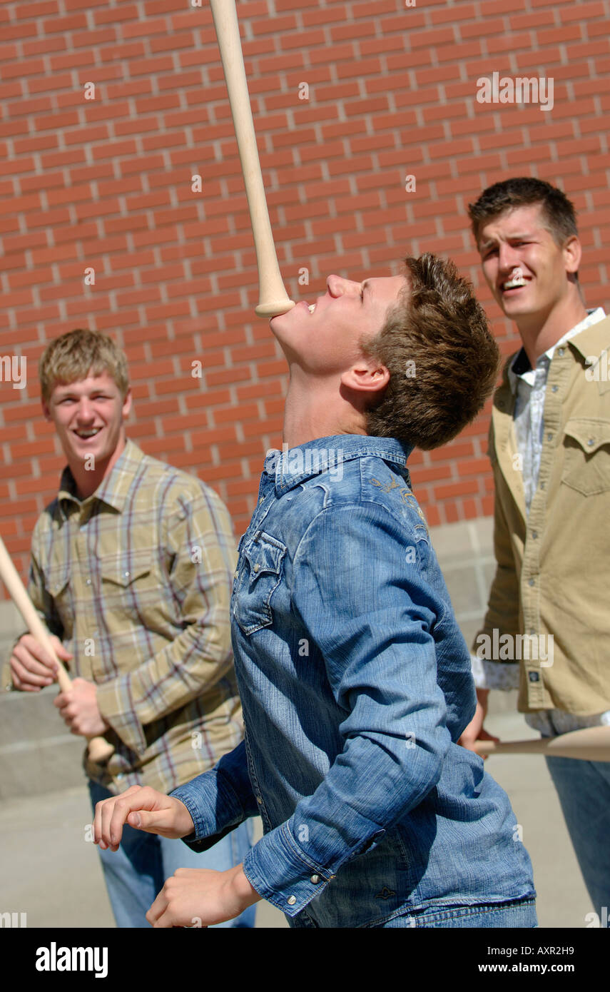 Youth balancing bats Stock Photo - Alamy