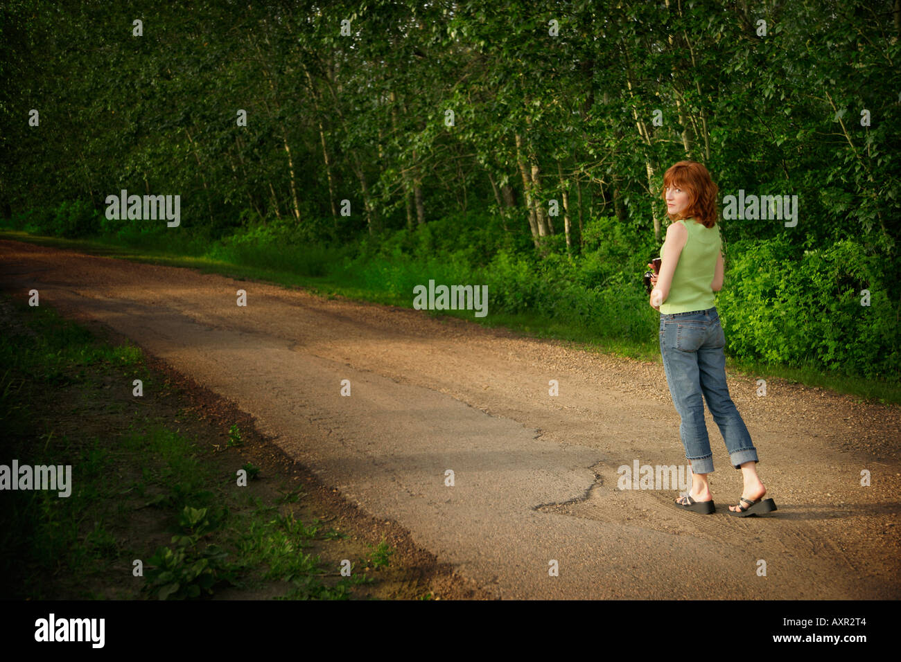 Woman walking down pathway Stock Photo - Alamy