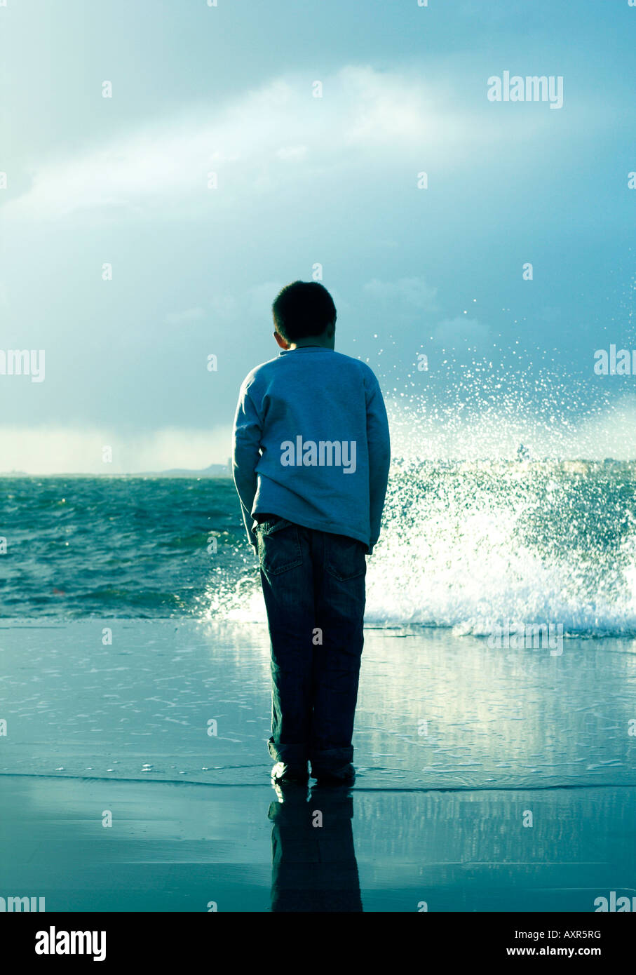 Boy standing sea watching waves hi-res stock photography and images - Alamy