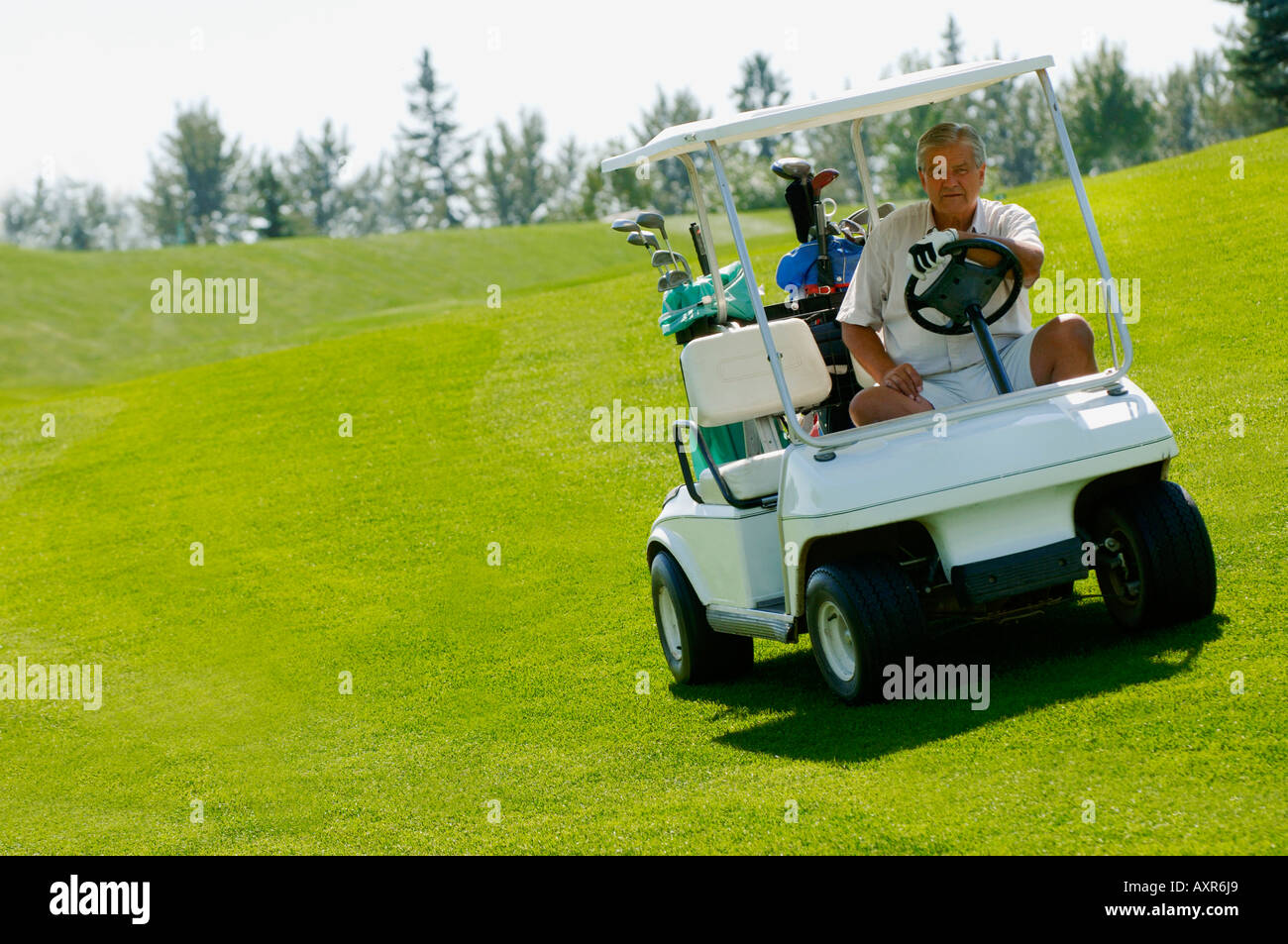 Man riding a golf cart Stock Photo - Alamy