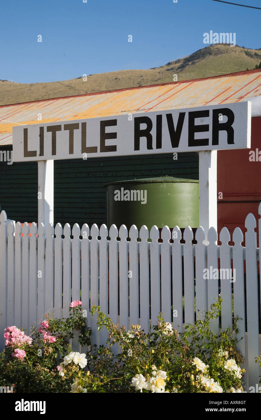 Village place name sign on white wooden picket fence outside old ...