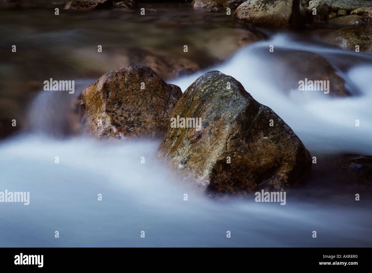 Water moving around large boulders Stock Photo - Alamy