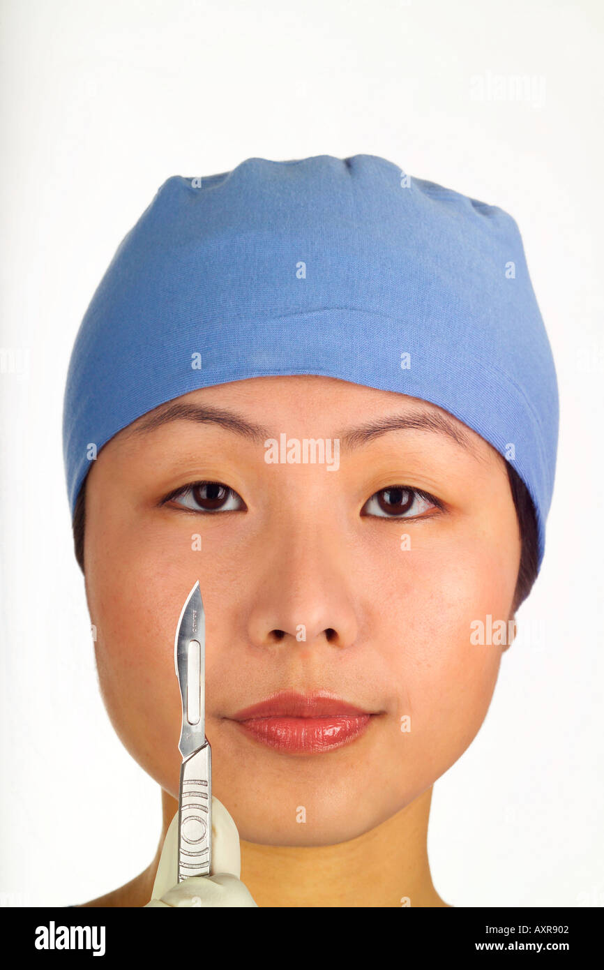Female Asian doctor or nurse is wearing surgical cap and holding a ...