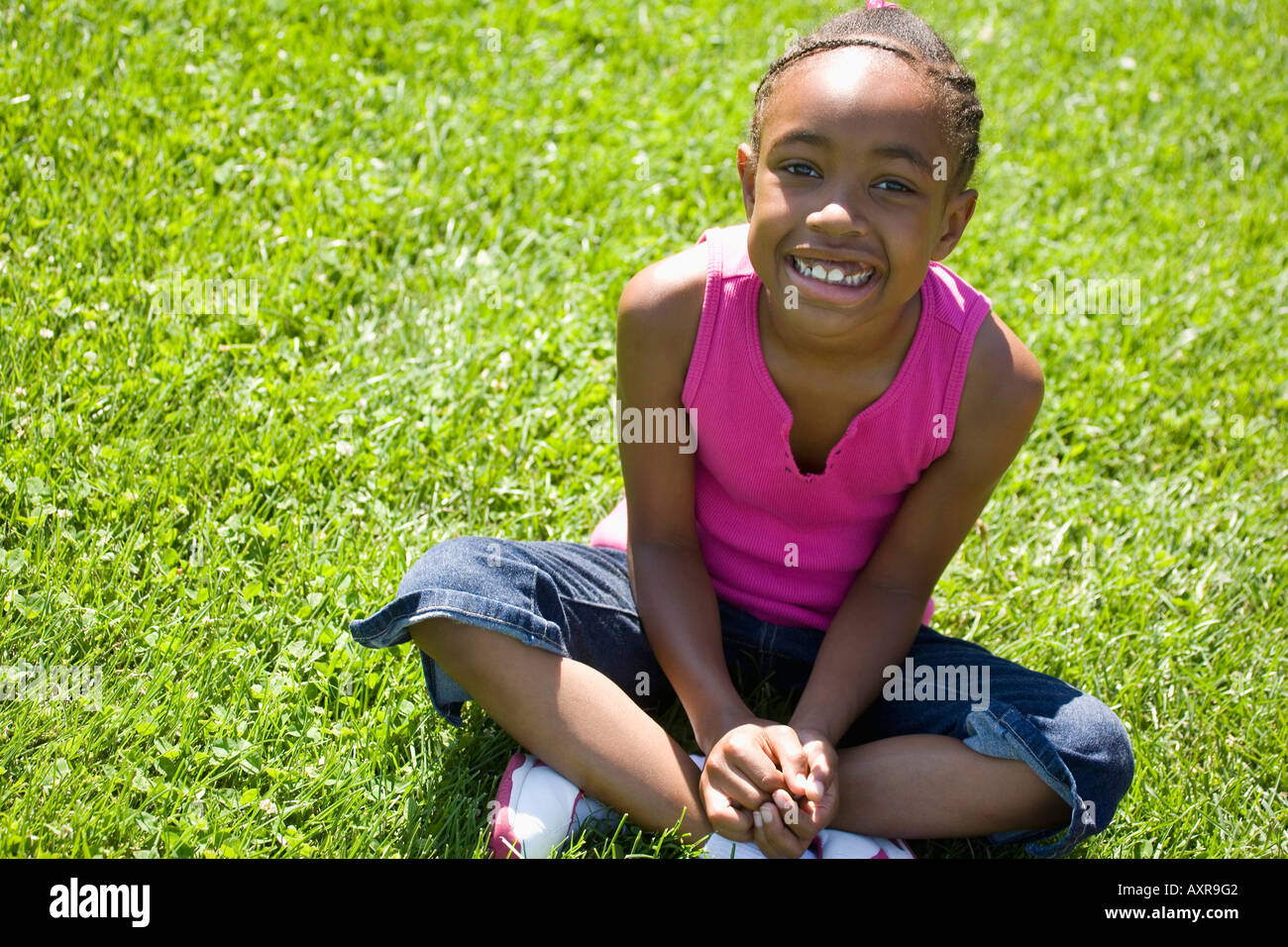 Girl sitting on grass Stock Photo - Alamy