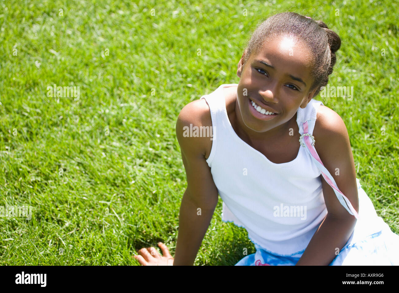 Girl sitting on grass Stock Photo - Alamy