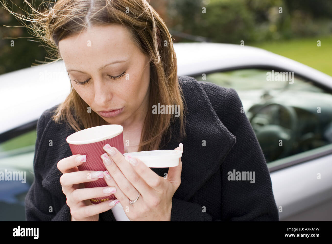Woman taking coffee break from driving Stock Photo - Alamy