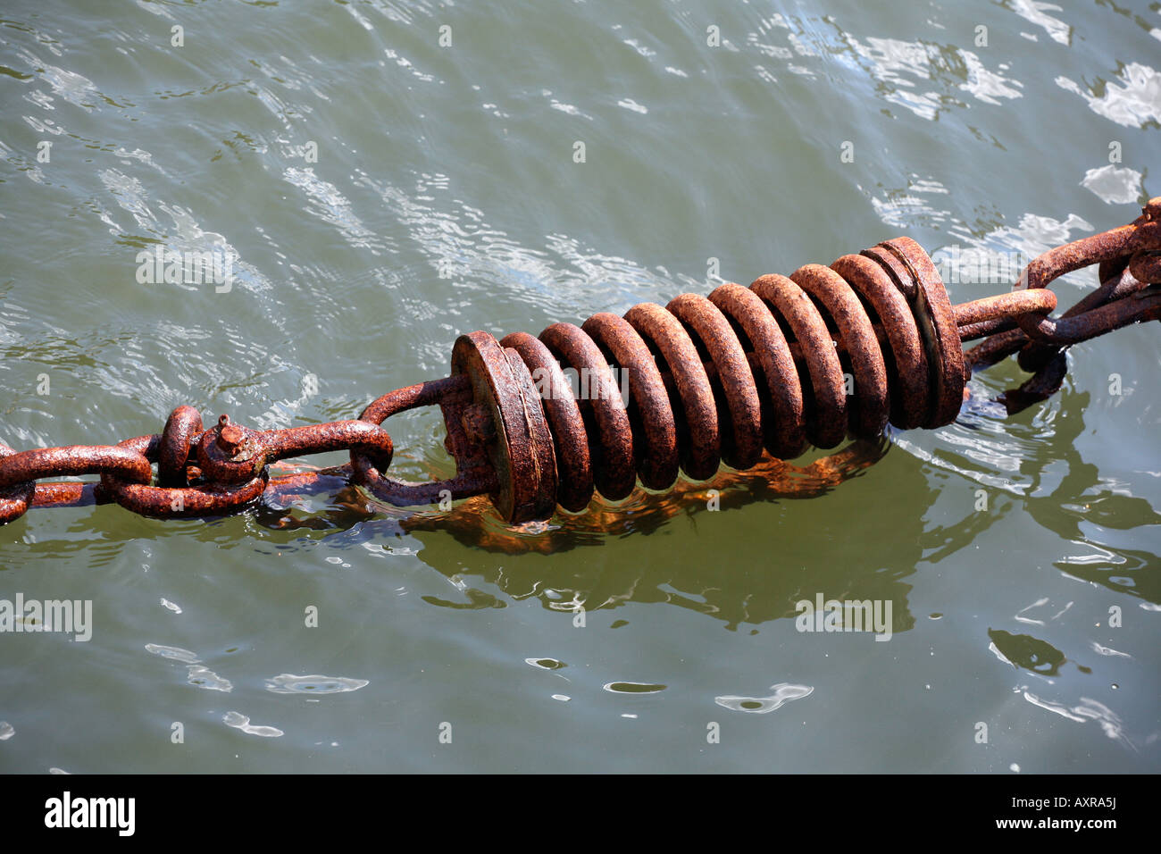 Large rusty spring holds floating dock to land Stock Photo - Alamy