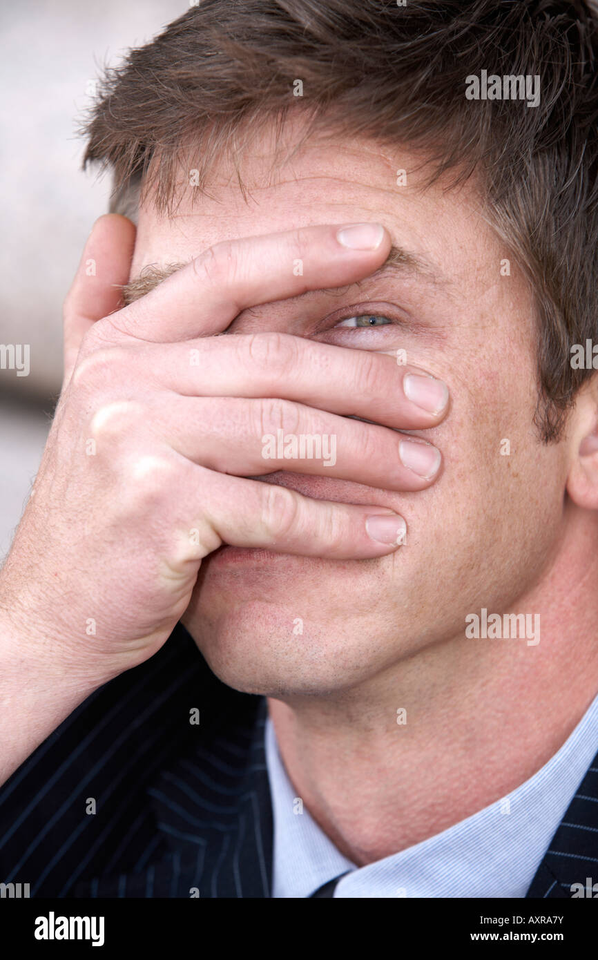 Man holding his face looking at camera Stock Photo - Alamy Man holding his face looking at camera Stock Photo - Alamy