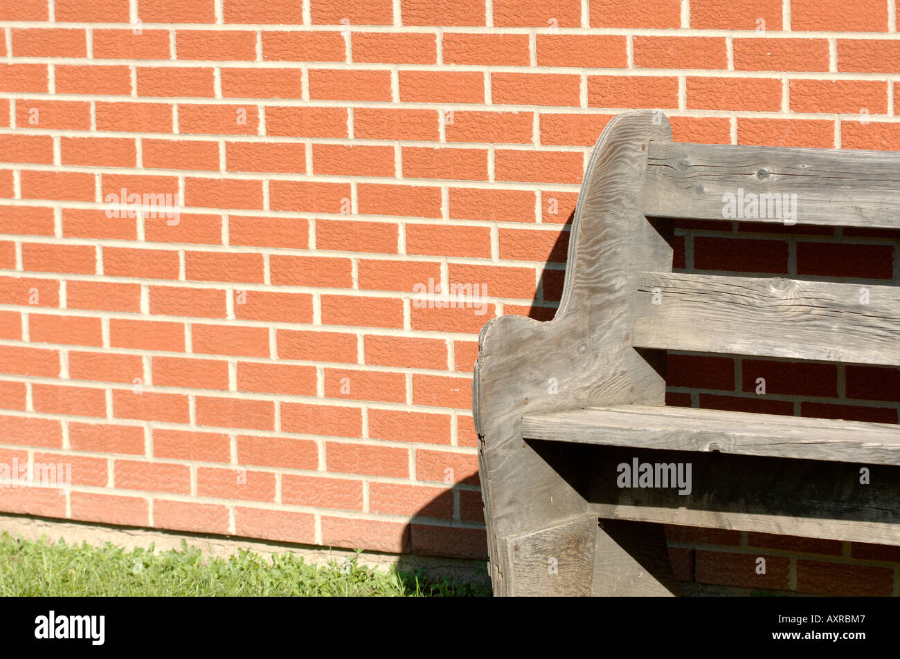 Wooden bench against brick wall Stock Photo - Alamy