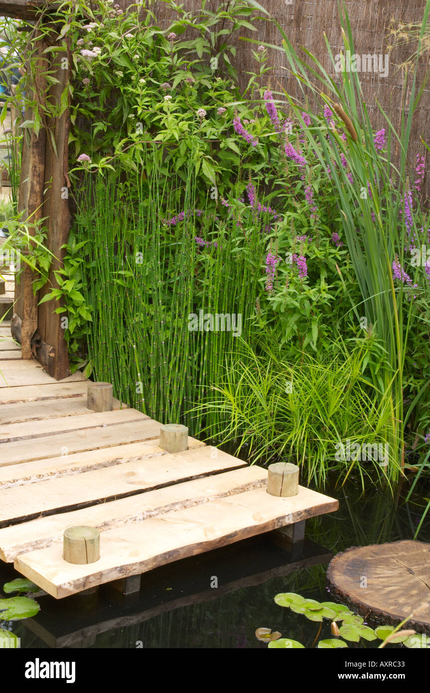 wooden decking leading out to steps across pool in garden Tatton Flower ...