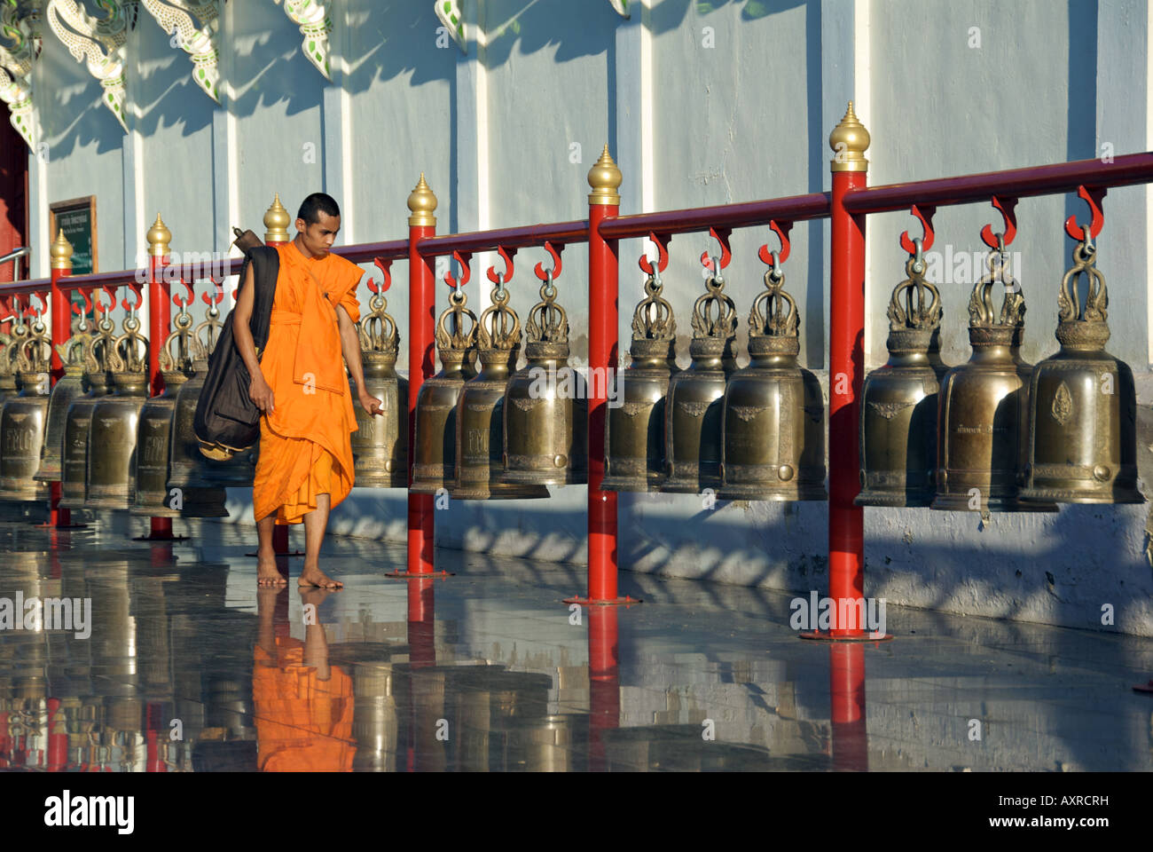 Monk at prayer gongs Wat Phra That Cho Hae Phrae Province Thailand ...