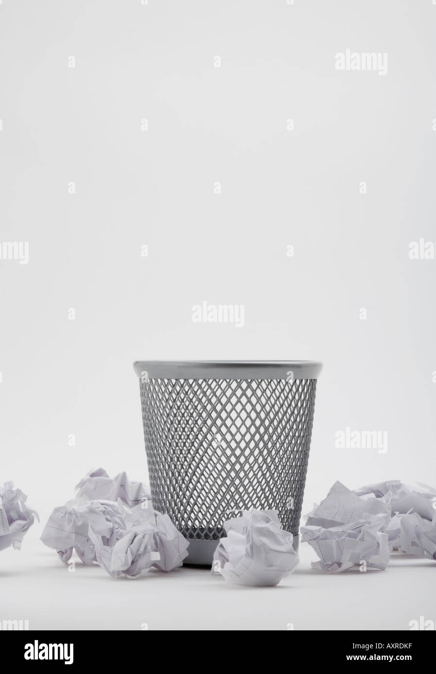Crumpled paper on floor around garbage can Stock Photo - Alamy