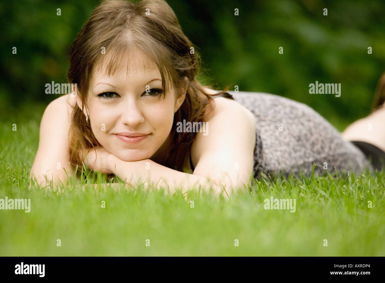 Woman laying on grass Stock Photo - Alamy