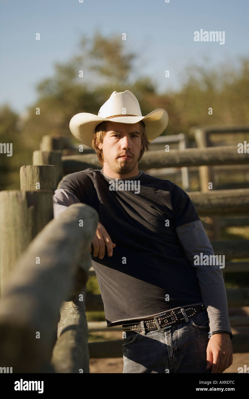 Cowboy standing by corral Stock Photo - Alamy