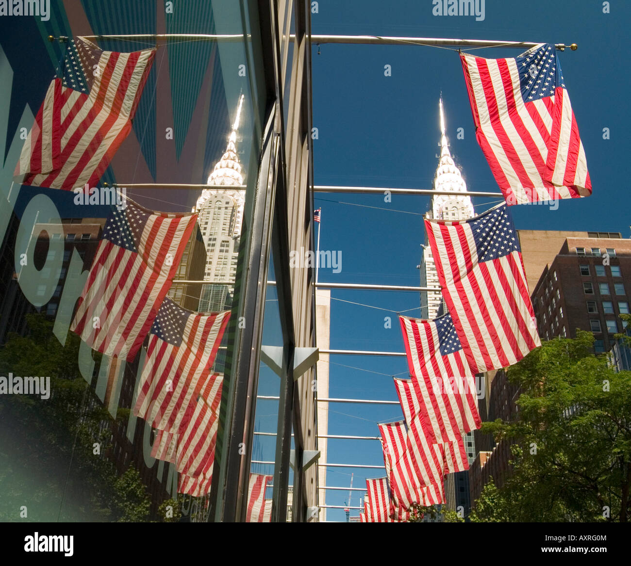 A row of American flags reflected in a window, with the Chrysler ...