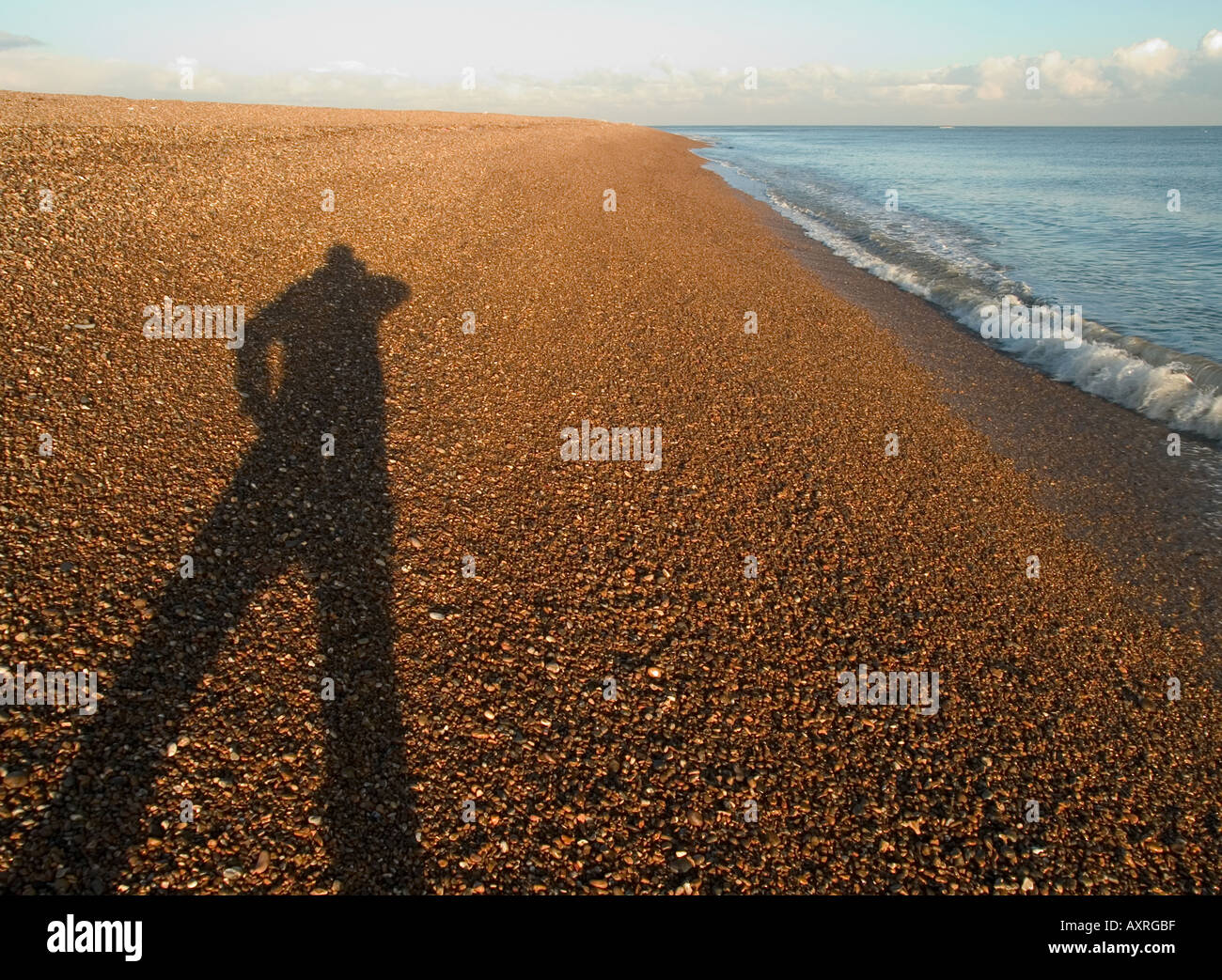 LONG SHADOW OF MAN CAST ON SHINGLE BEACH AT SHINGLE STREET,SUFFOLK,EAST ...