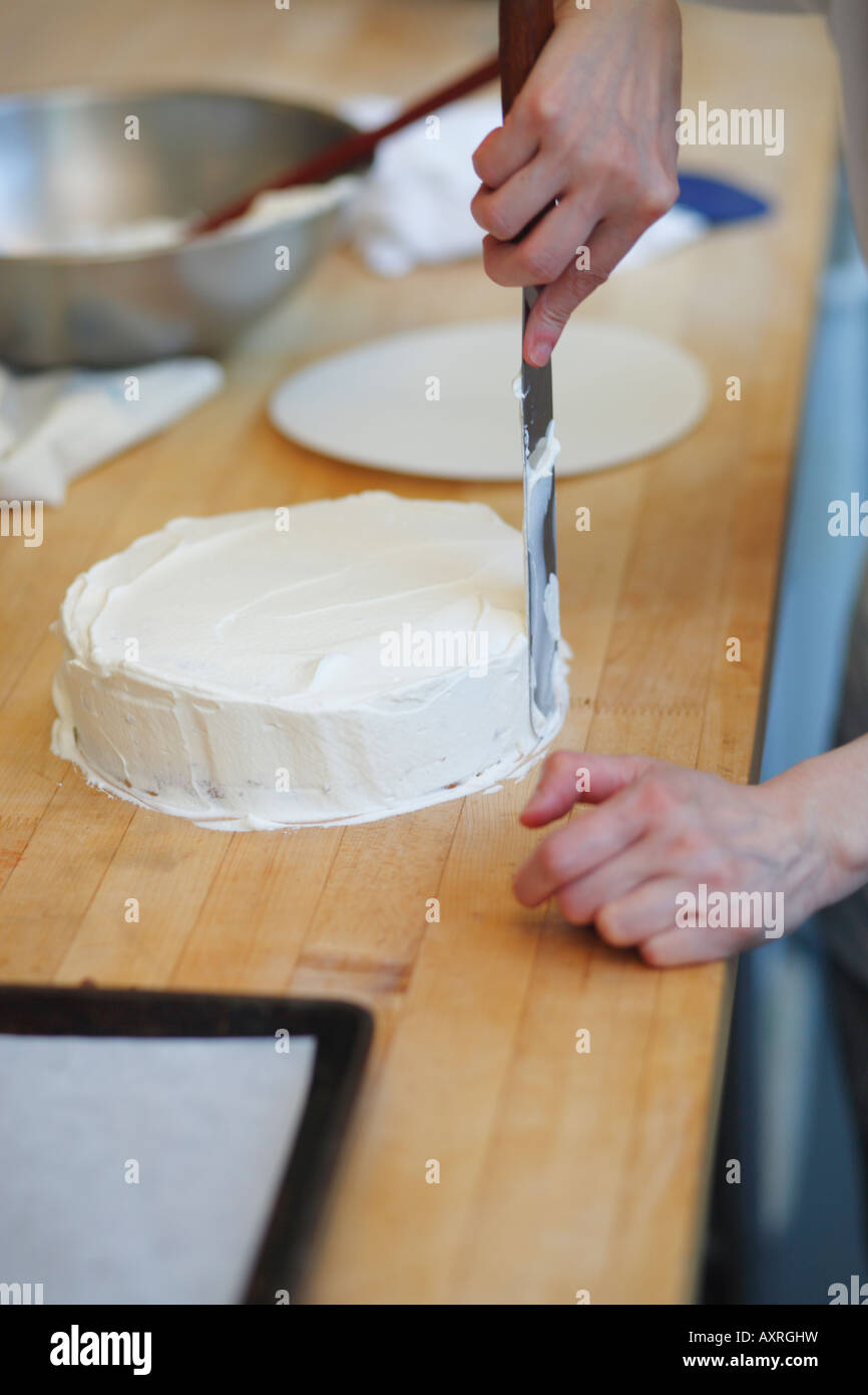 Pastry chef spreading icing over cake Stock Photo - Alamy