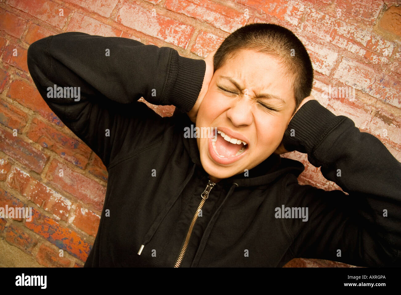 Young woman covering ears and screaming Stock Photo - Alamy