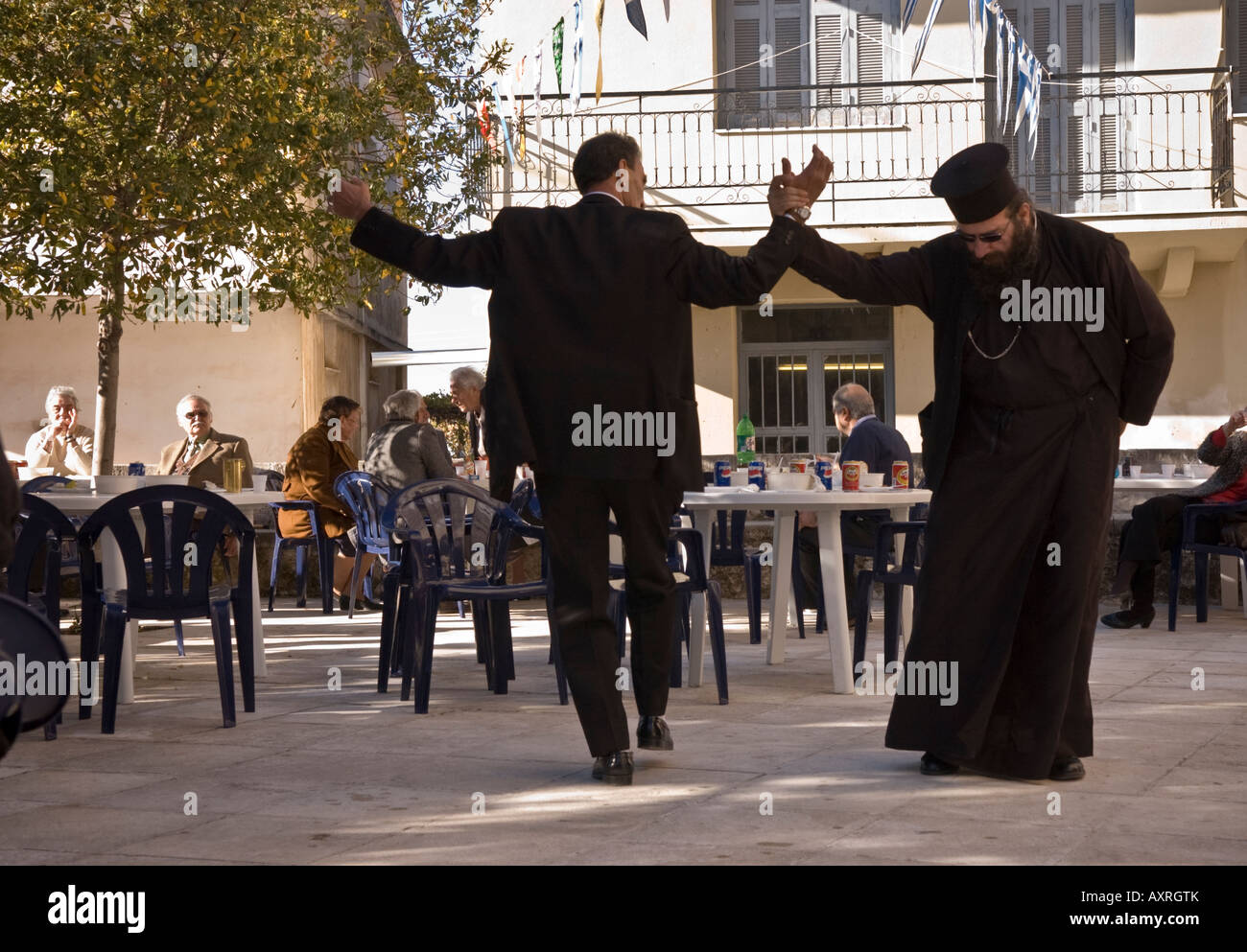 A priest and villager dancing at a Paniyiri, a local festival, Proastio ...