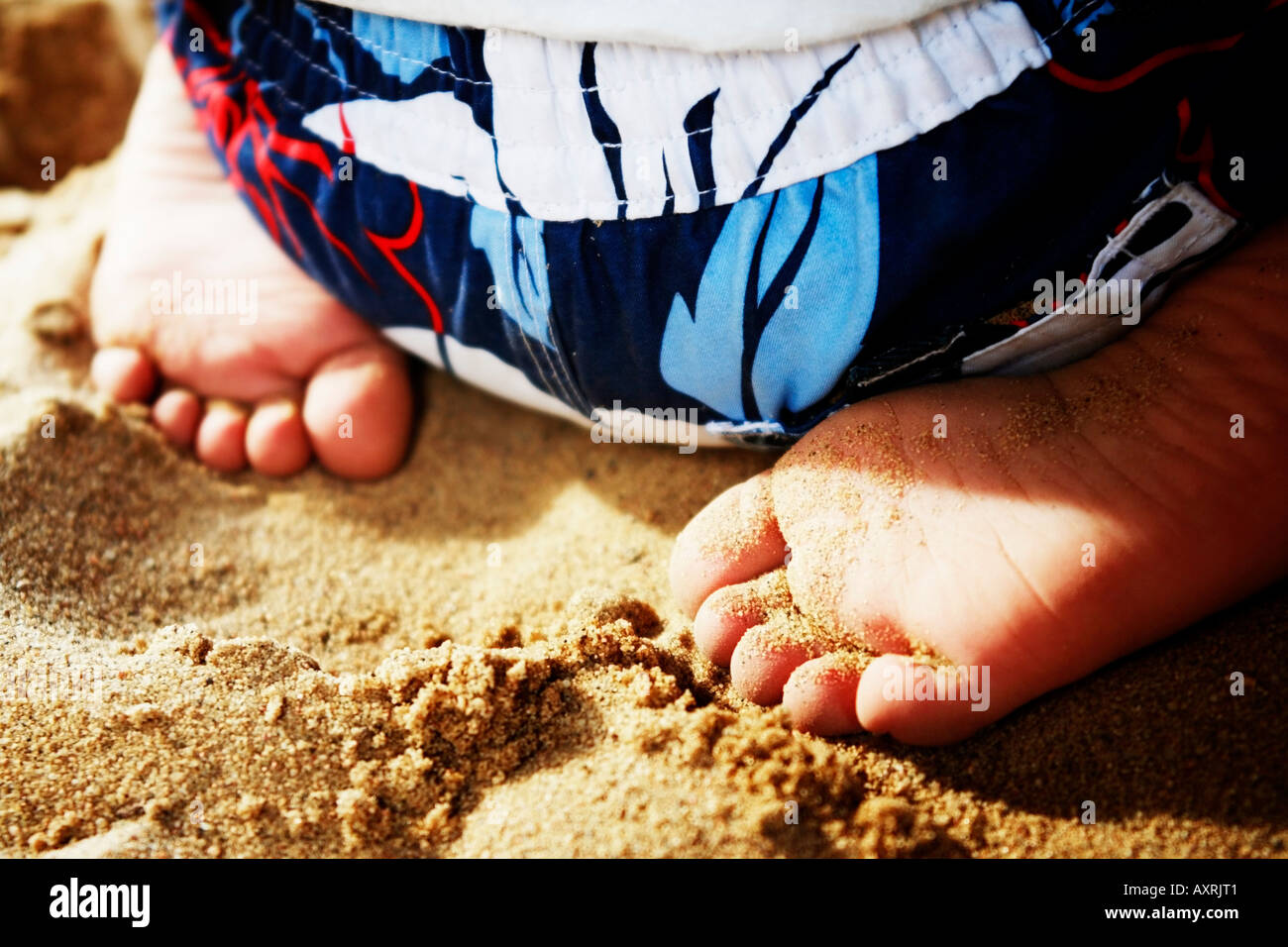 Child sitting in sand Stock Photo - Alamy