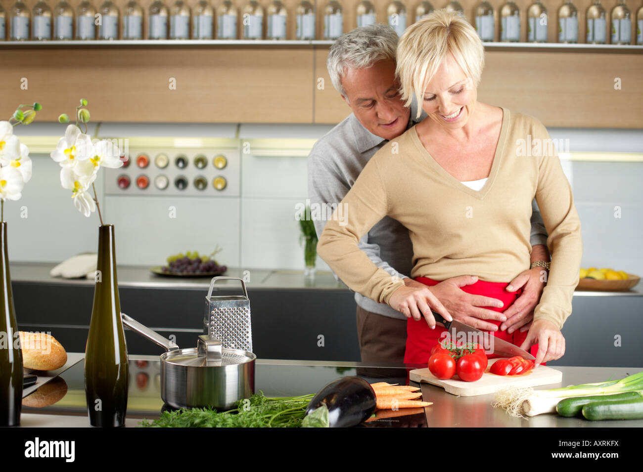 Blond woman and gray-haired man cooking together Stock Photo - Alamy