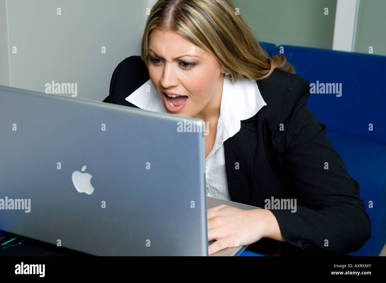 woman angry at something on laptop Stock Photo - Alamy