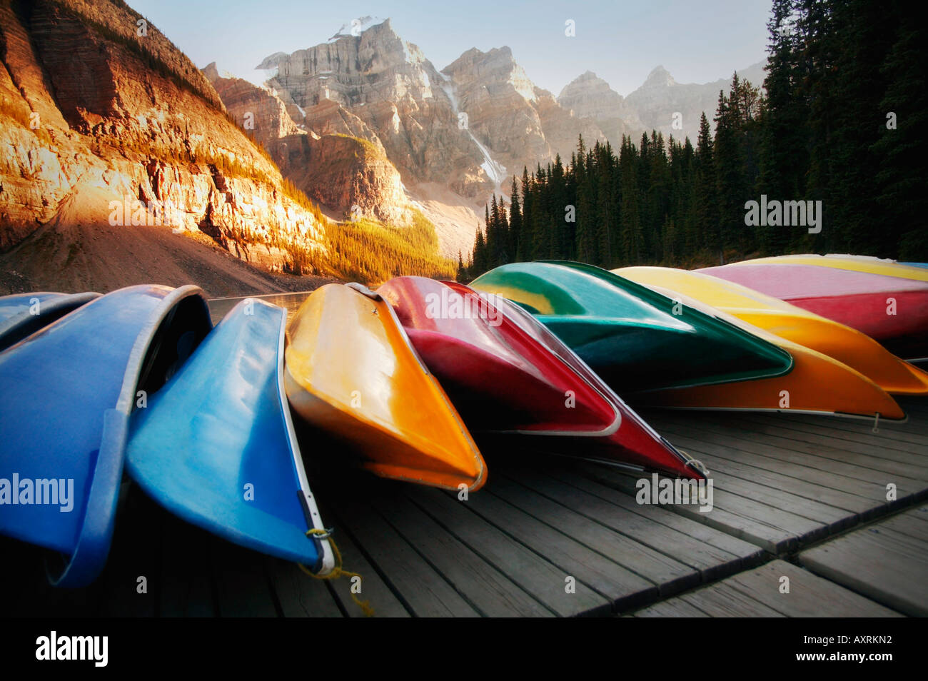 Multi colored canoes resting on a dock Stock Photo - Alamy