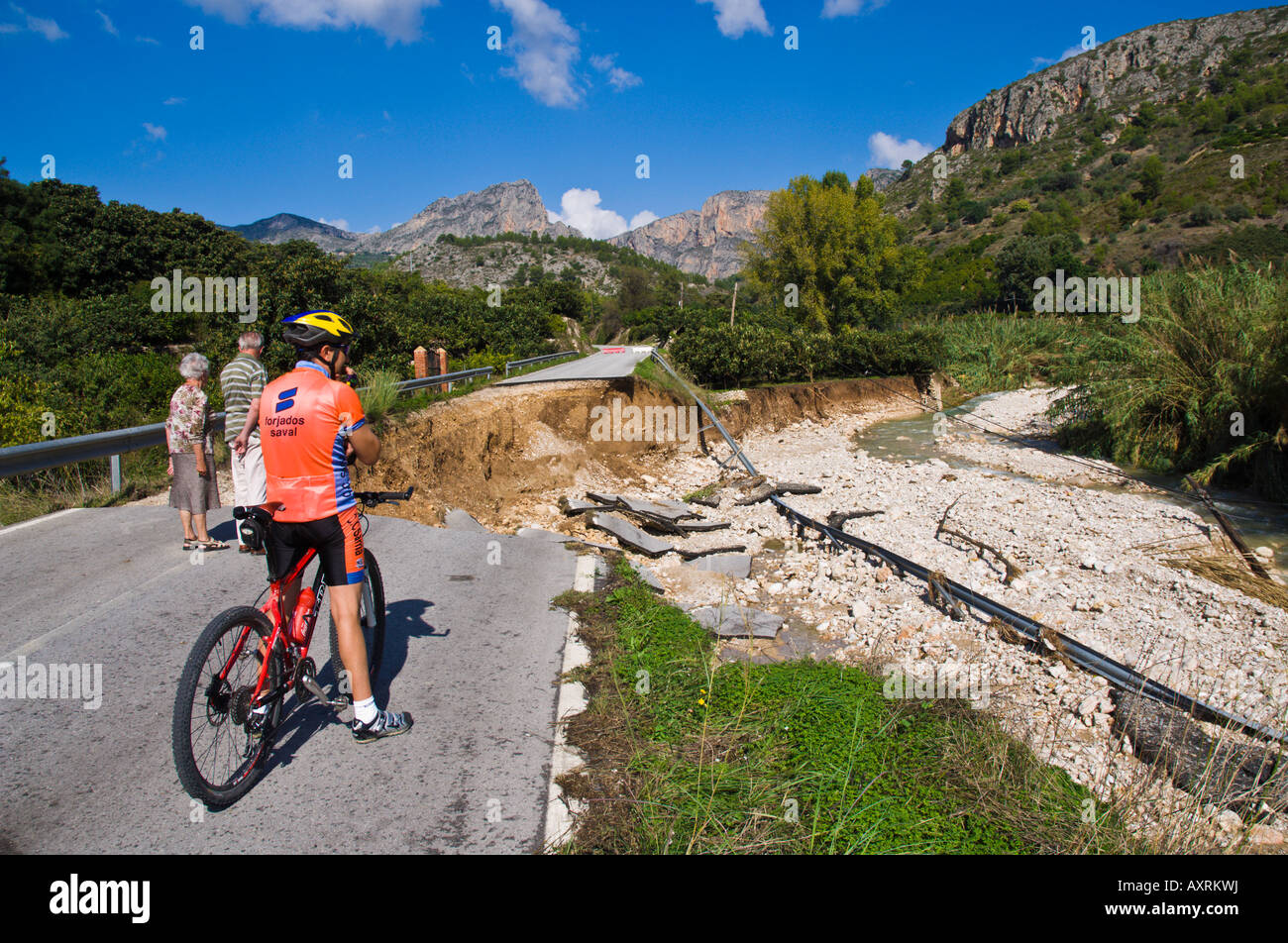 A cyclist finds his path blocked due to a collapsed road caused by ...