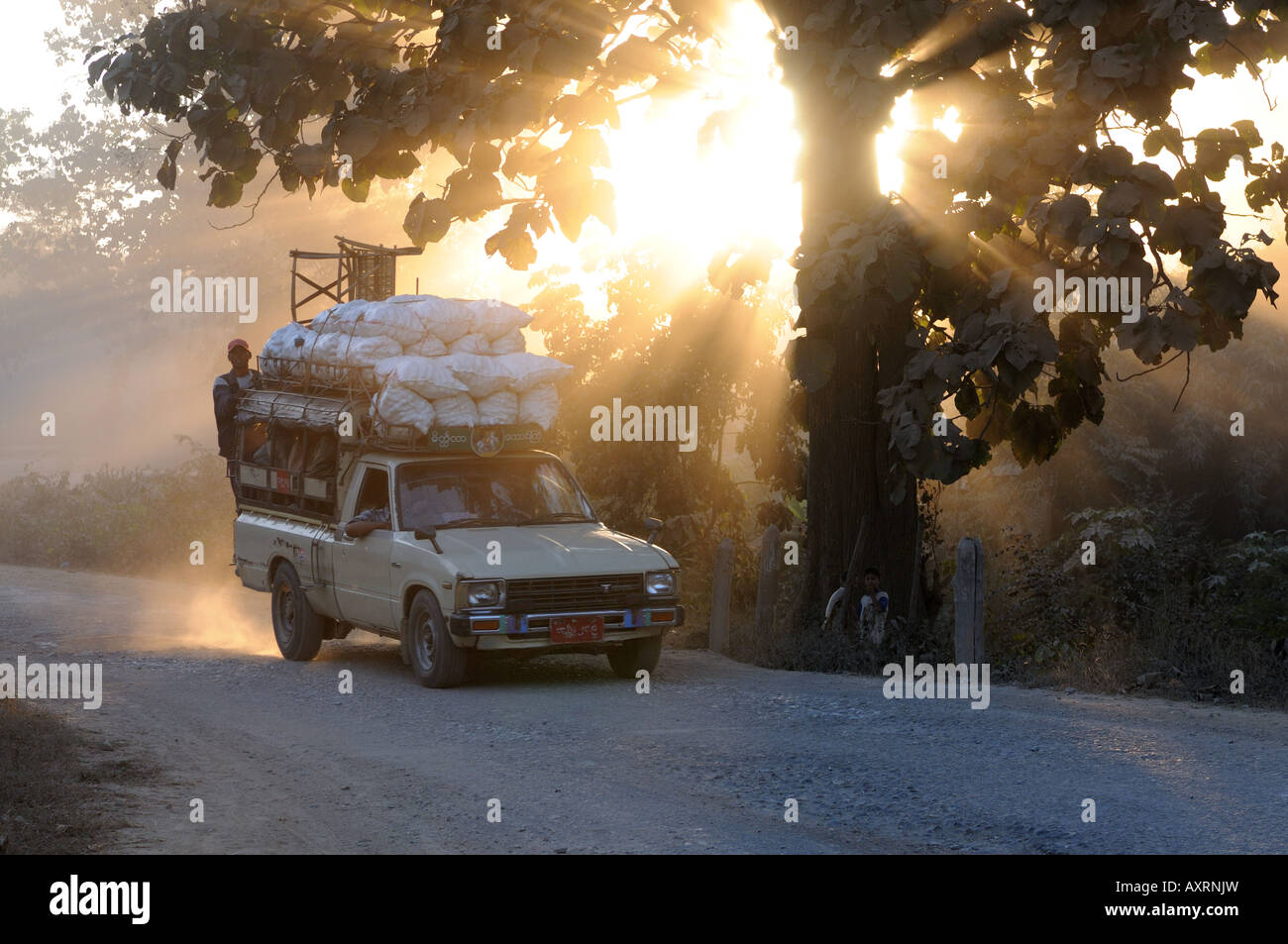 Loaded pick up truck in the silhouette of the down going sun near Kalaw ...