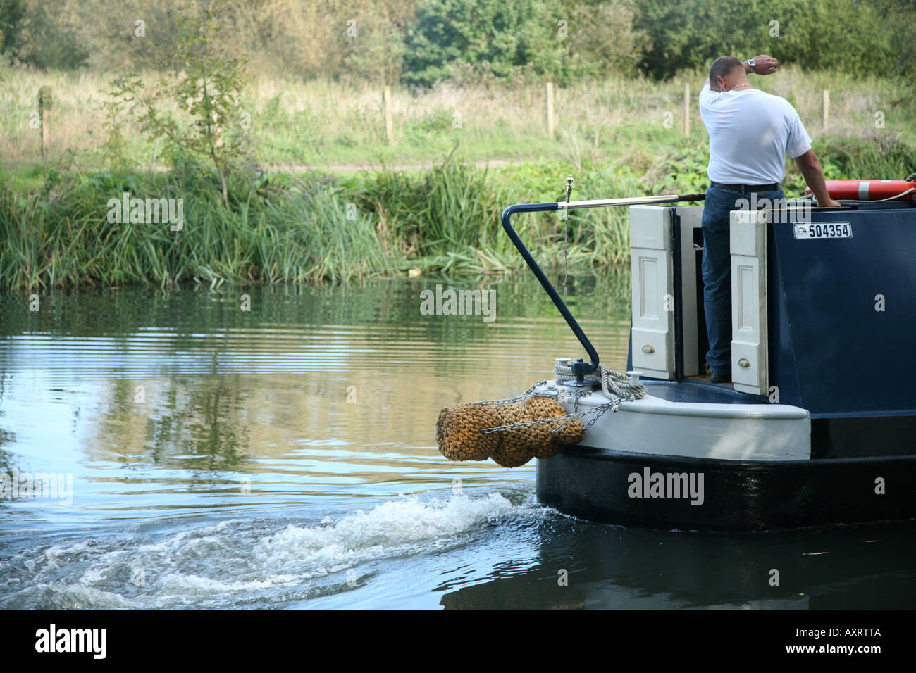 A man driving a narrow boat and who is crying Stock Photo - Alamy