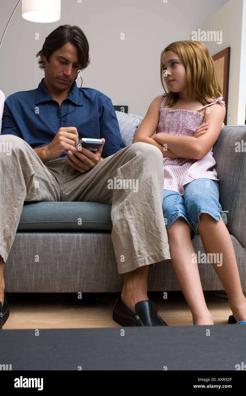 Portrait of a young girl bothering her dad who is on the phone Stock ...