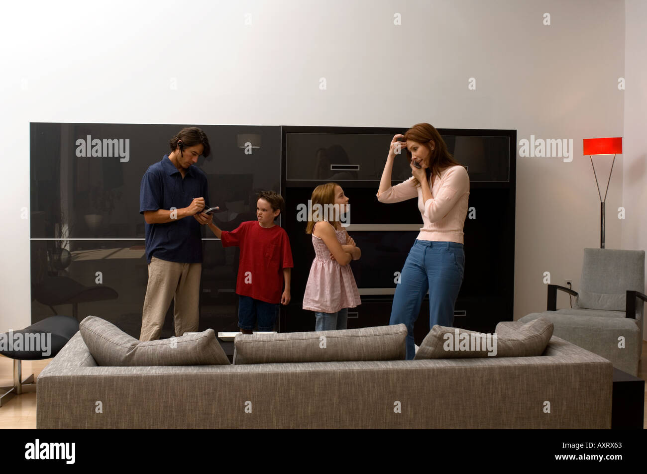 Portrait of two kids bothering their parents who are busy Stock Photo ...