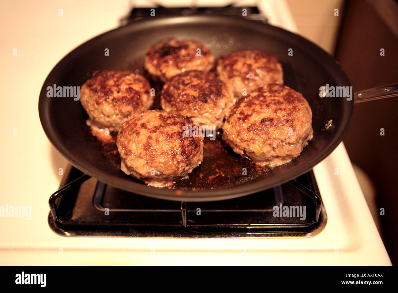 BEEF BURGERS FRYING ON A PAN Stock Photo - Alamy