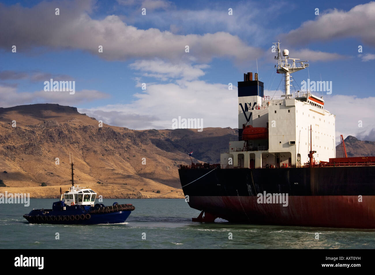 A tug is stationed at the stern of a bulk carrier for it's arrival into ...