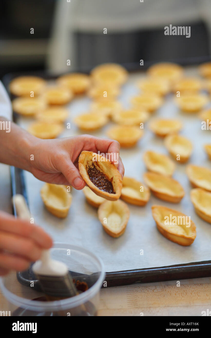 Filling pastry boats with chocolate Stock Photo - Alamy